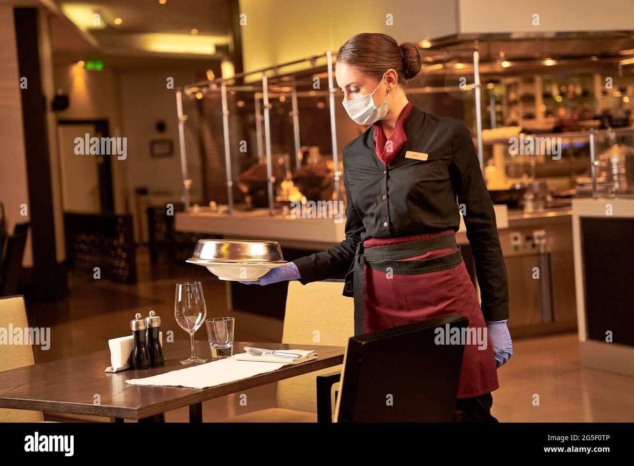 Helpful waitress serving the order to table Stock Photo - Alamy