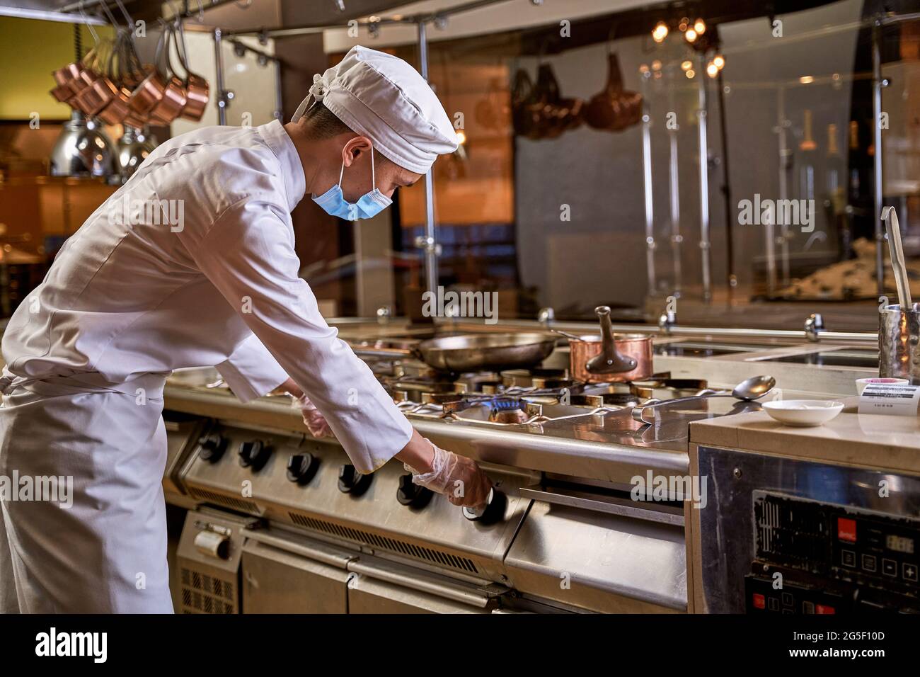 Male chef controlling flame of a stove burner Stock Photo - Alamy