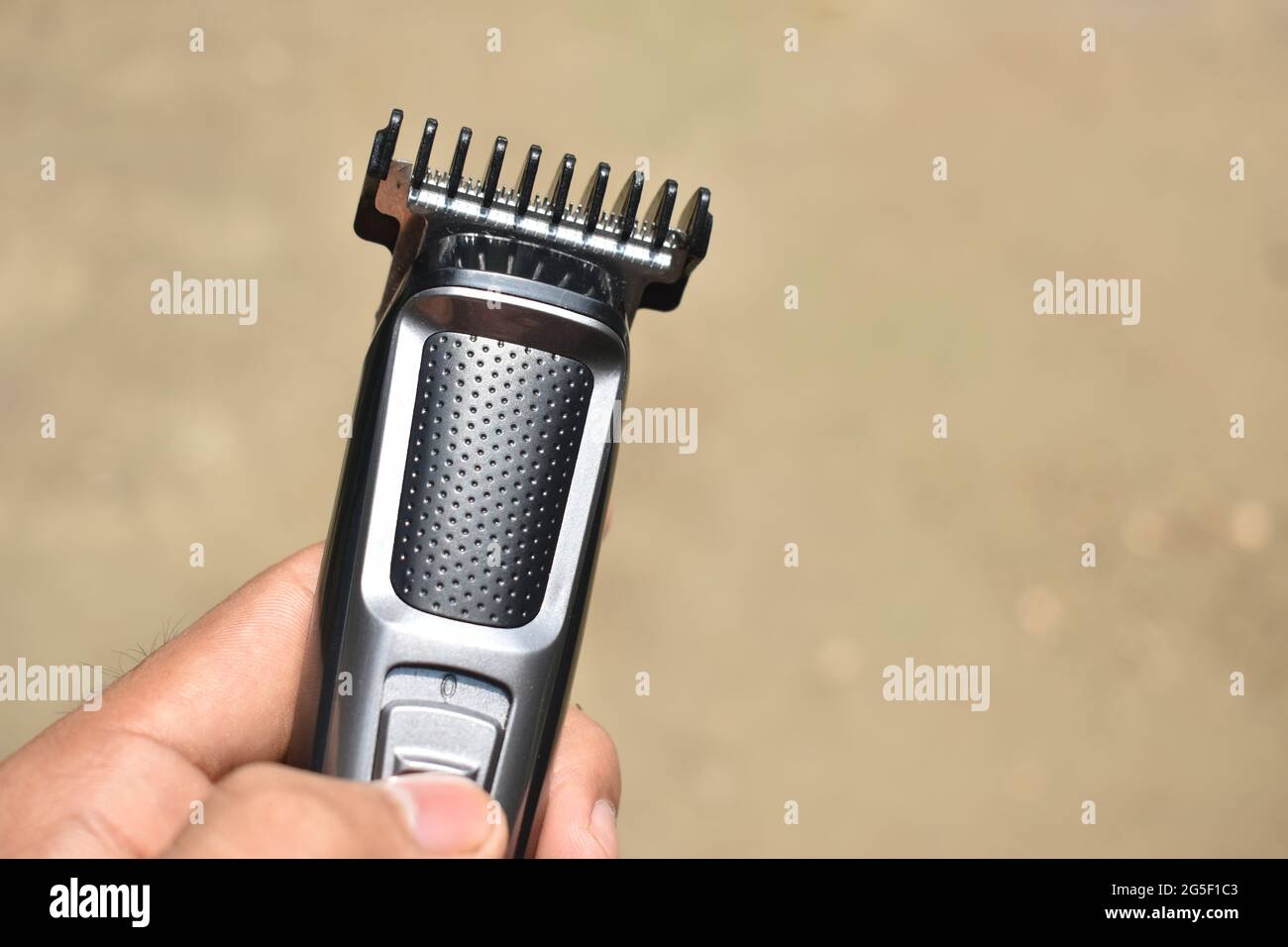 A closeup of a black clipper on a man's hand Stock Photo - Alamy