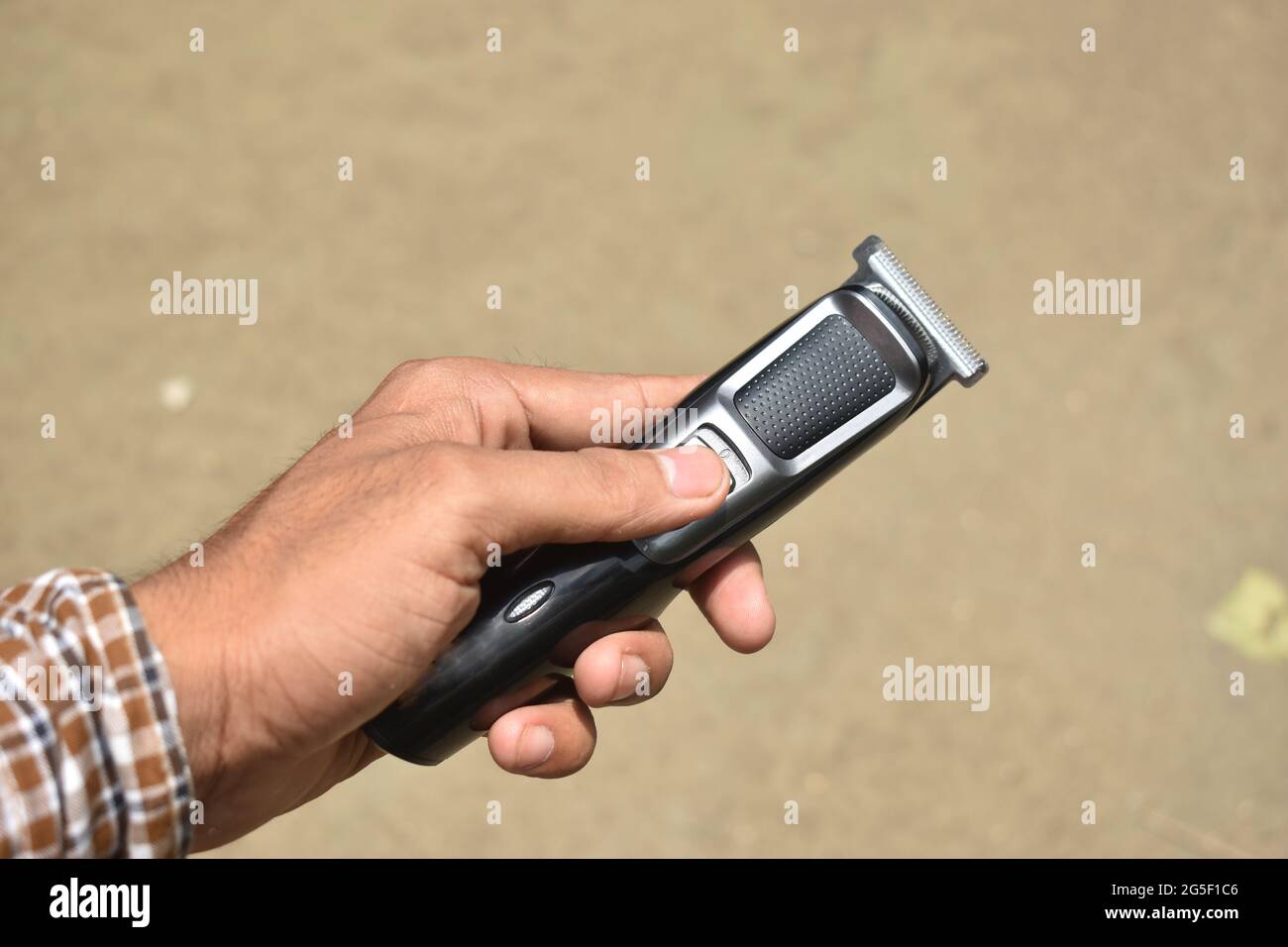 A closeup of a black clipper on a man's hand Stock Photo - Alamy