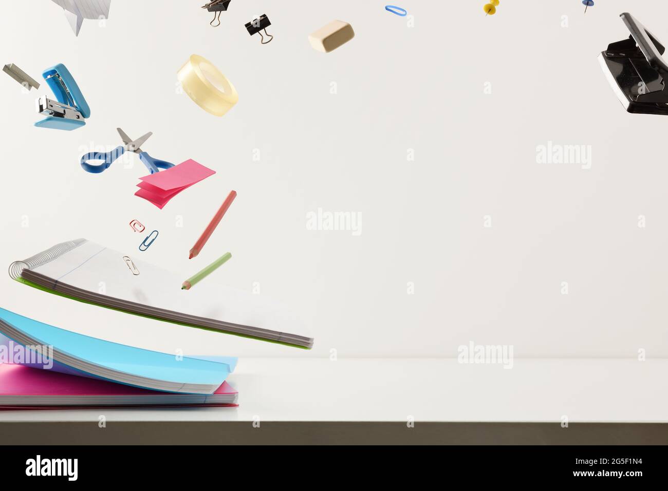 Study desk and chool supplies flying with white isolated background ...