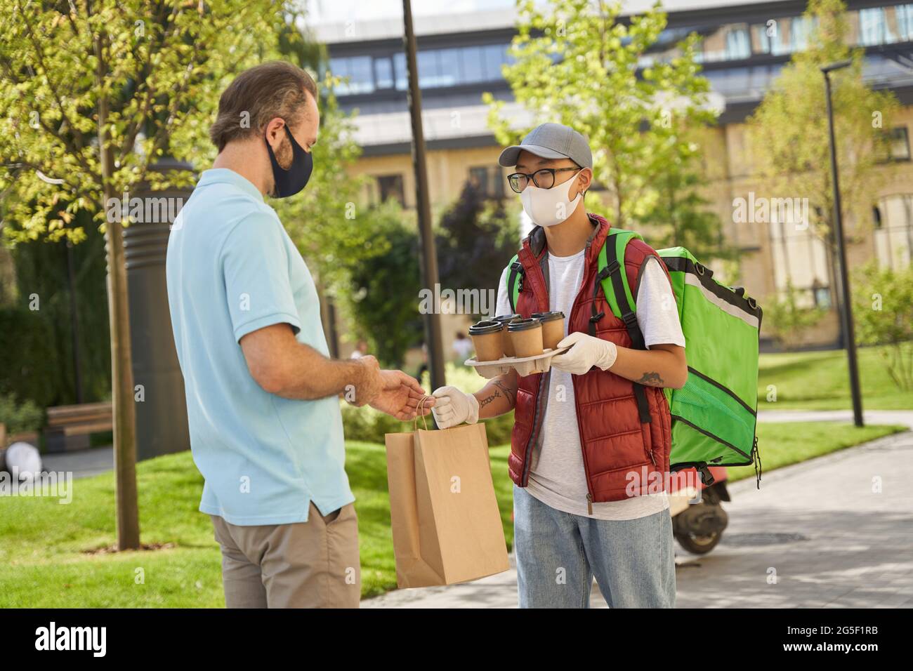 No contact delivery during covid 19 outbreak. Young asian courie Stock ...