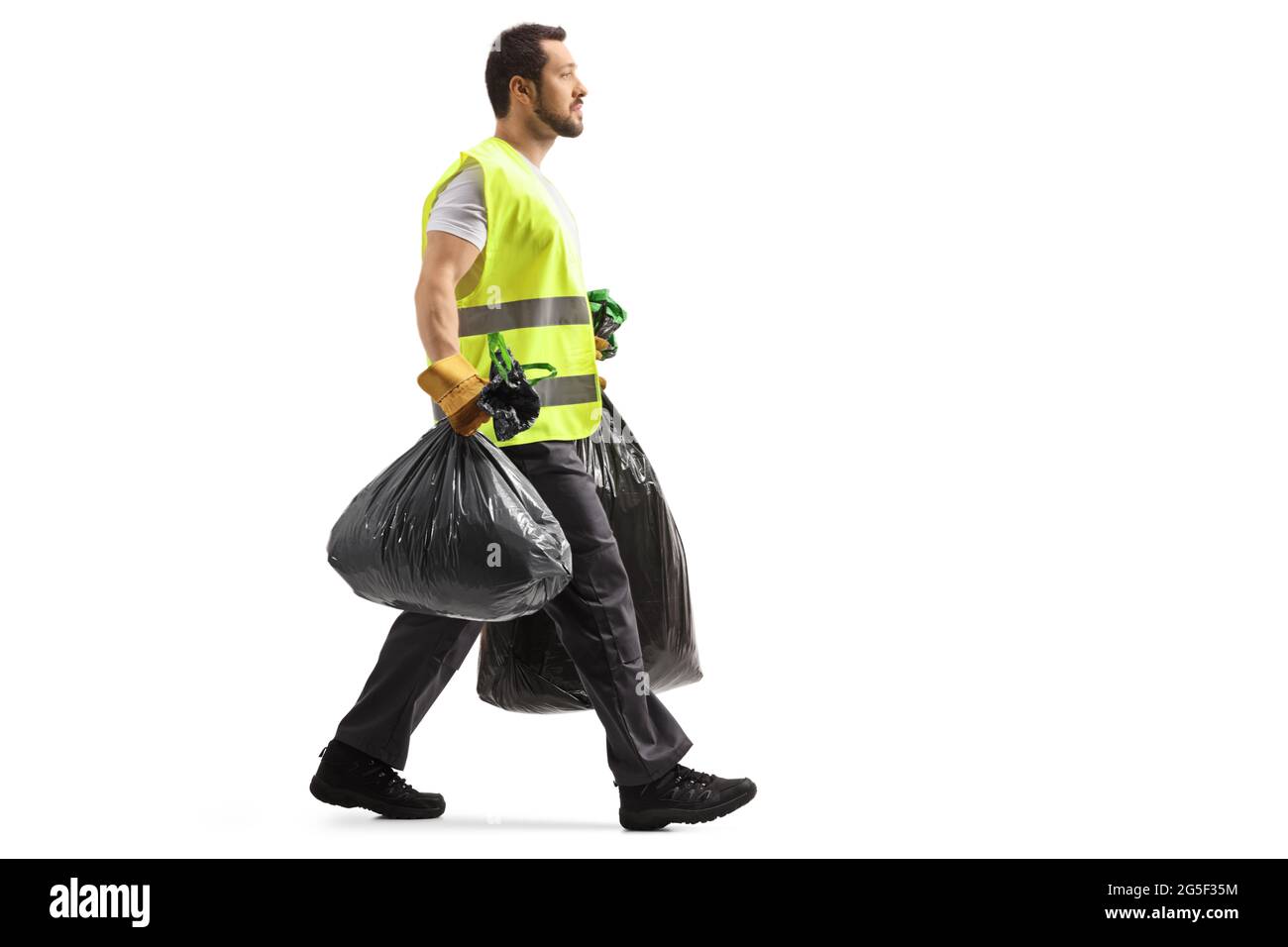 Full length profile shot of a garbage man walking and carrying bin bags ...