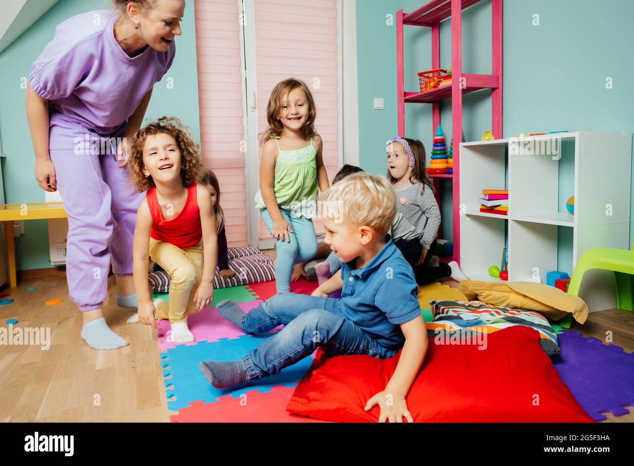Happy kids actively playing at the daycare Stock Photo - Alamy