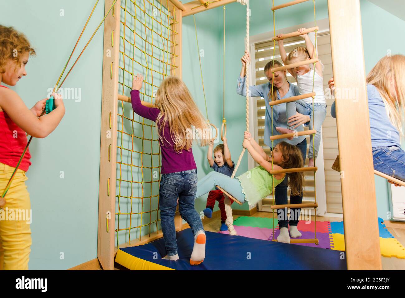 Physical training lesson at a wooden sport complex at the kindergarten ...