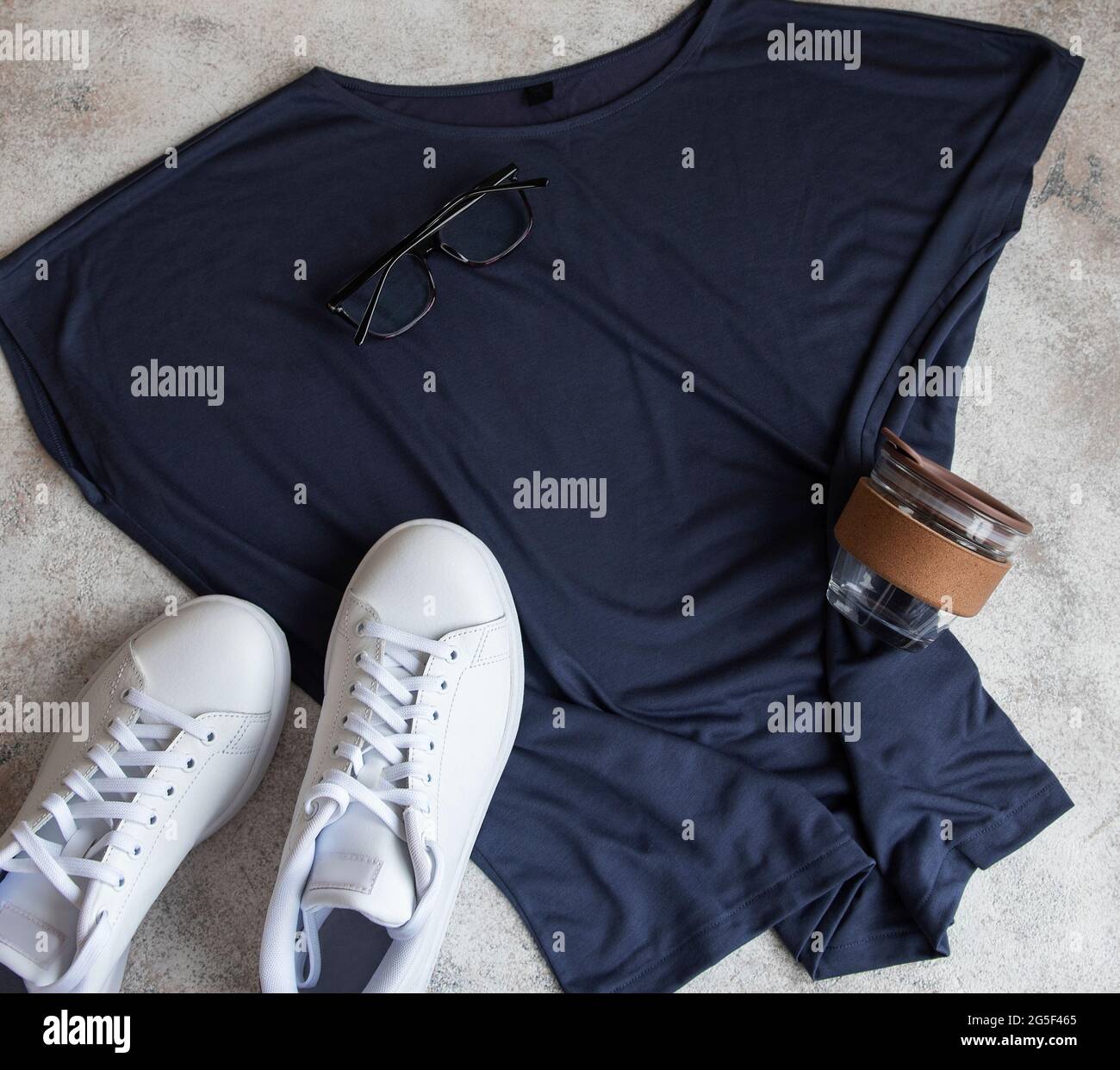 Stylish female clothes set. Woman outfit on concrete background. Blue t ...