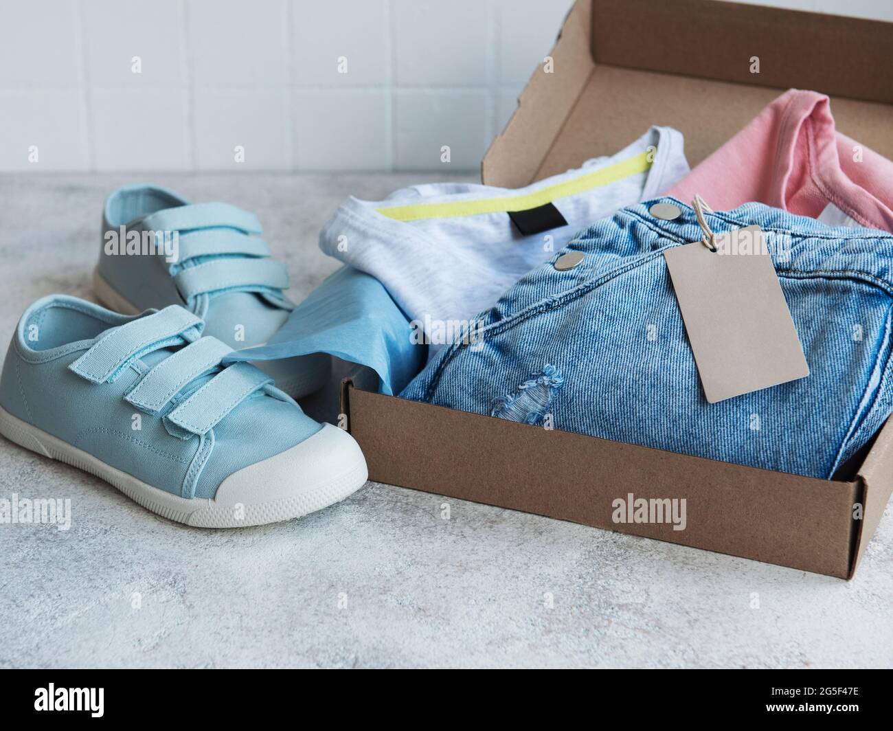Clothes for kids in an open cardboard box. Online shopping concept ...