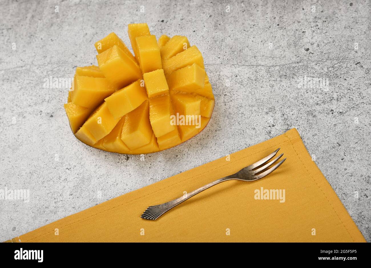 Close up serving fresh ripe cut mango dessert on gray stone table ...