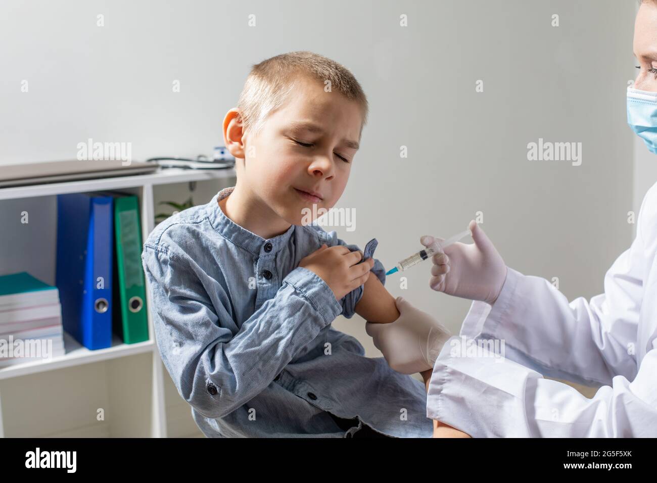 Portrait of lovely brave preschooler boy while routine vaccination ...