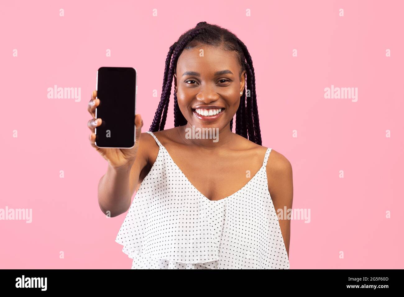 Positive African American lady holding cellphone with mockup for design ...