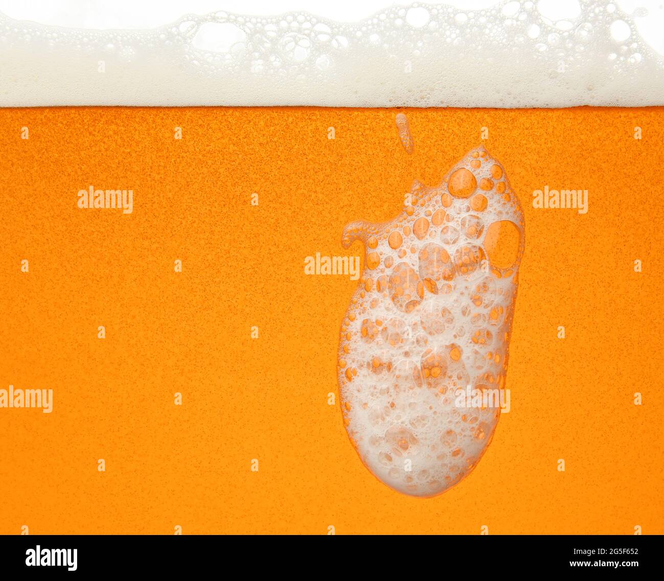 Close up background texture of lager beer with bubbles and froth ...