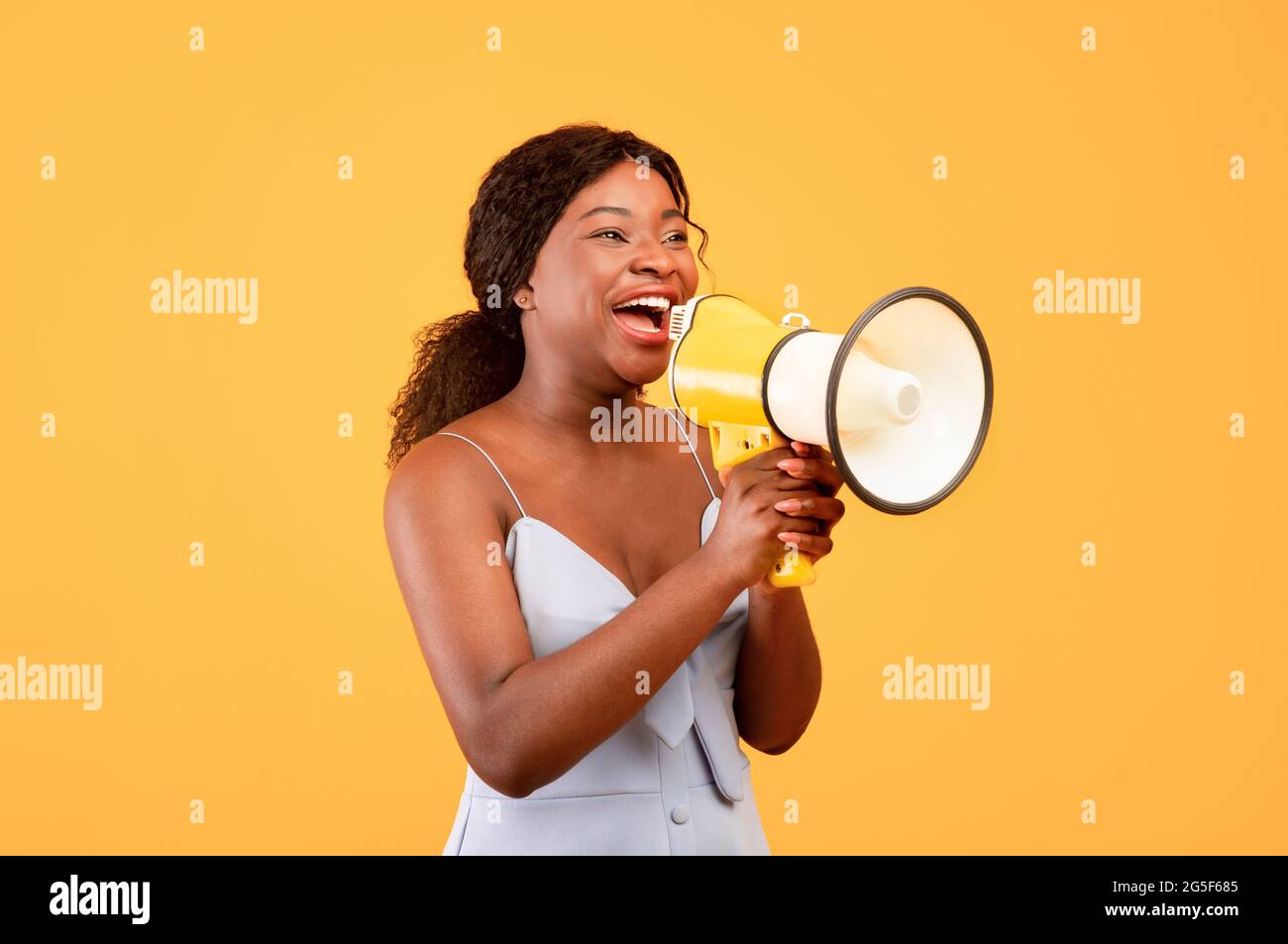 Amazing shopping offer. Young black woman shouting into megaphone ...