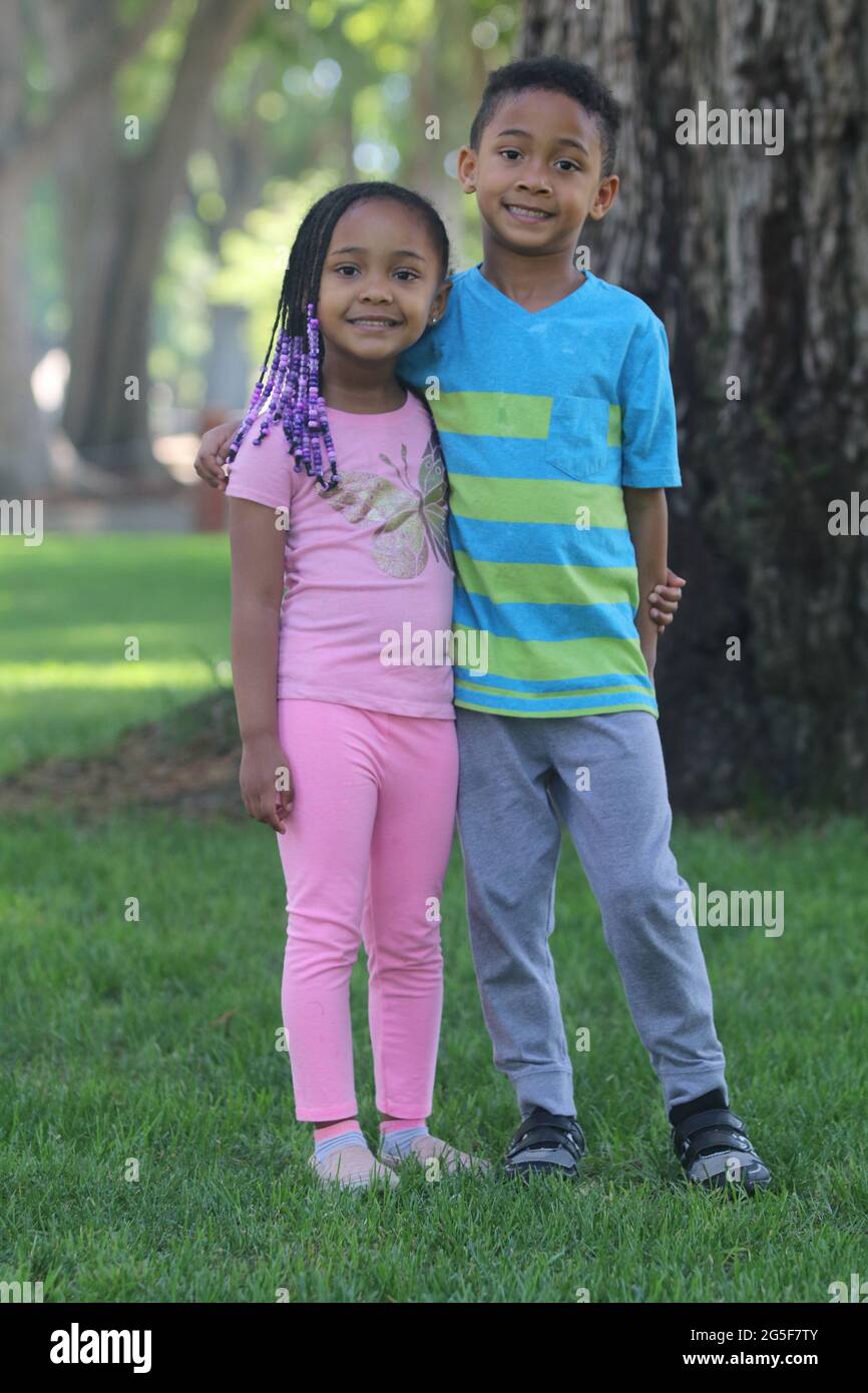 A shallow focus of two African American kids holding each other with ...