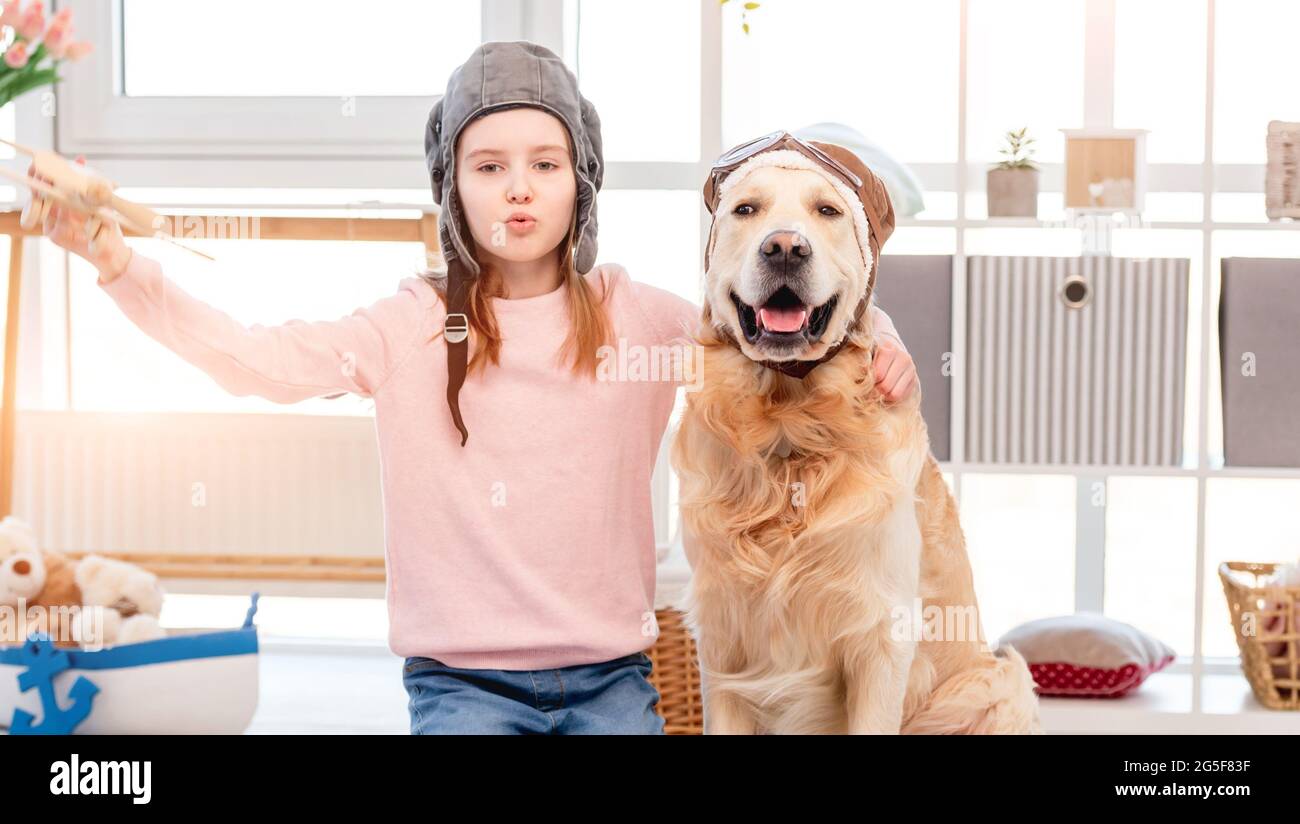 Little girl play in plane pilot with golden retriever dog Stock Photo ...
