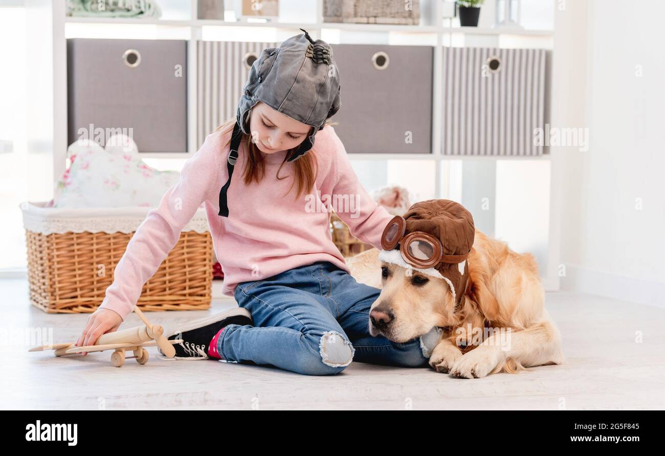 Little girl play in plane pilot with golden retriever dog Stock Photo ...