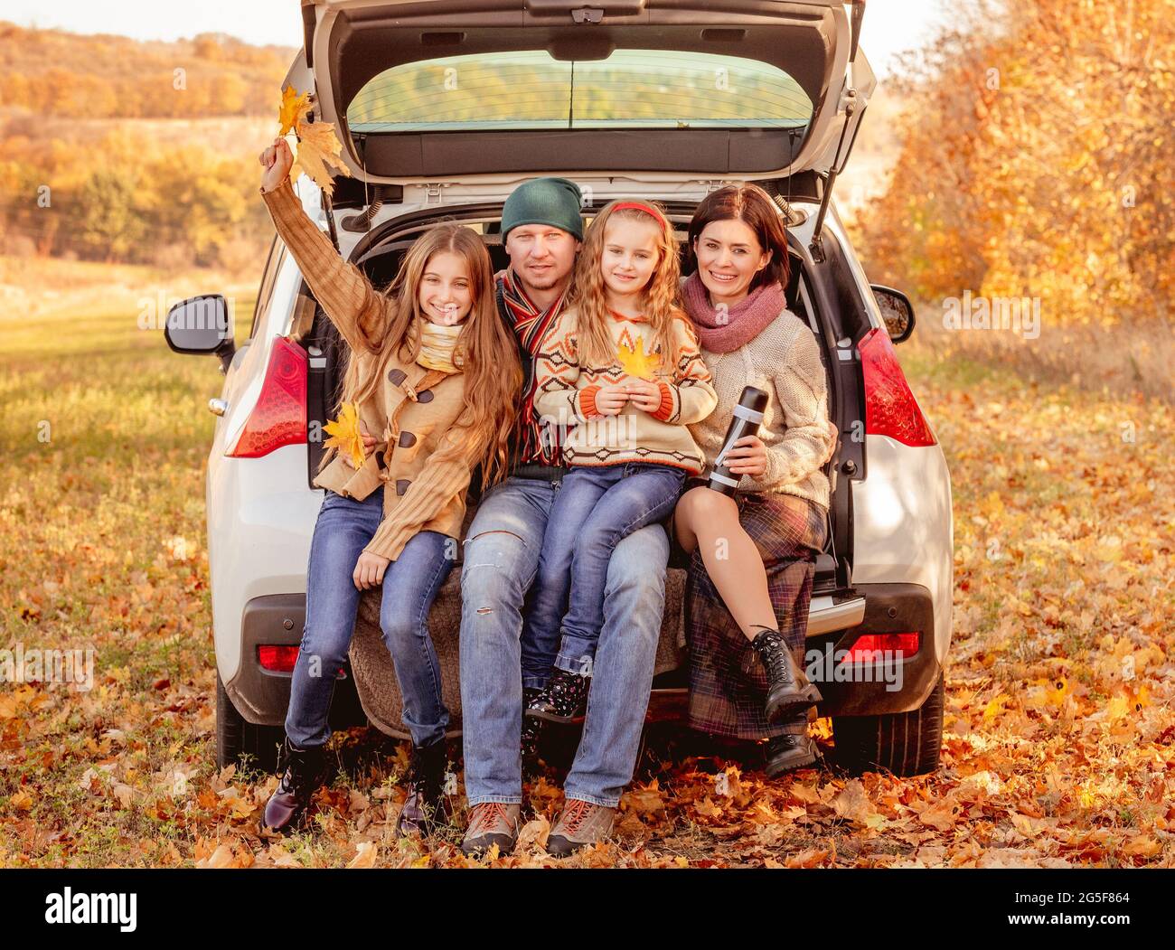 Family sitting in car trunk Stock Photo - Alamy