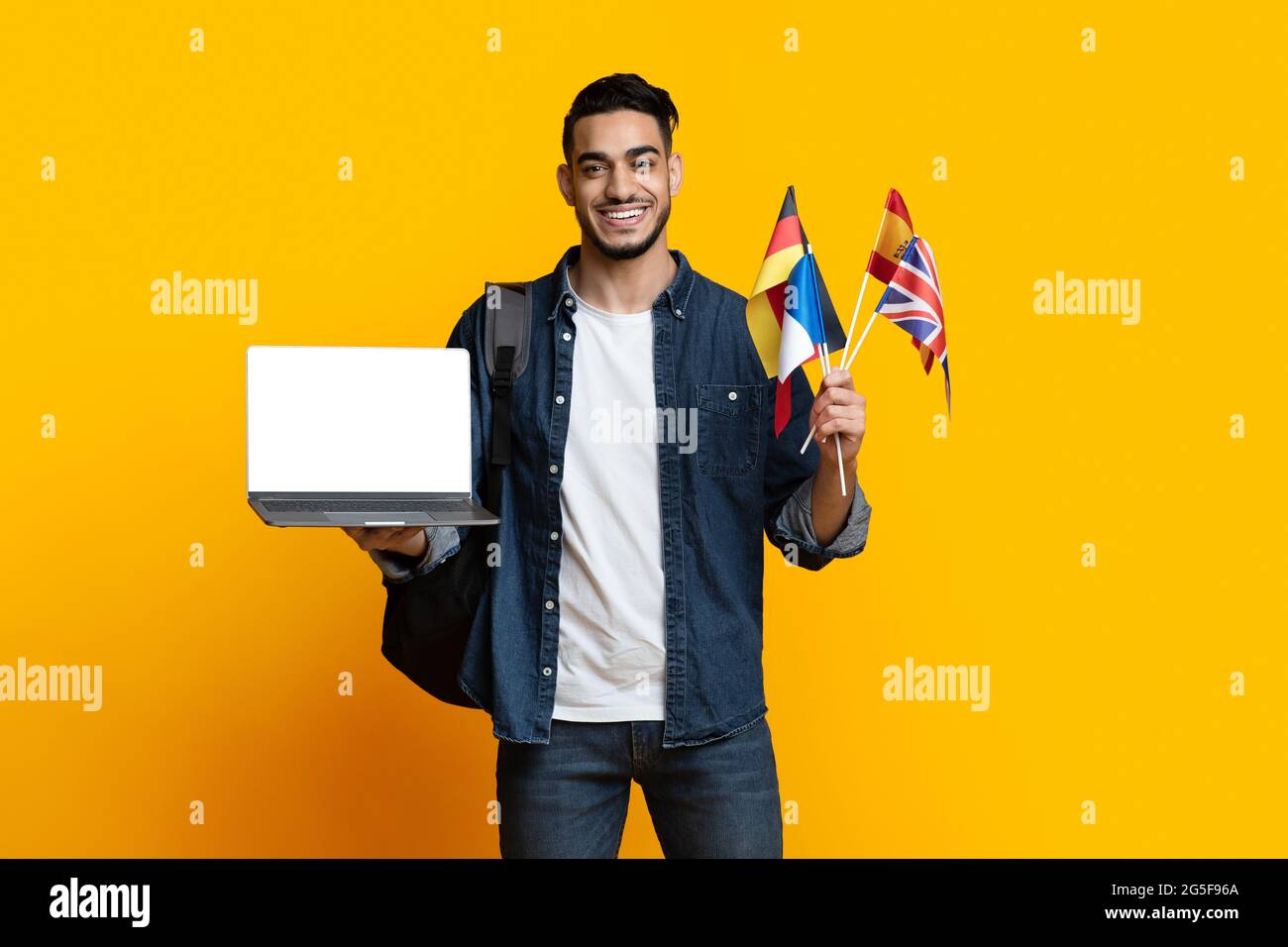 Happy arab man student showing laptop with empty screen and bunch of ...