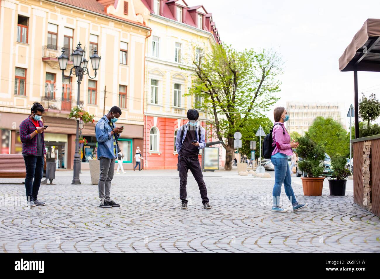 People in masks stand queue keeping social distance Stock Photo - Alamy