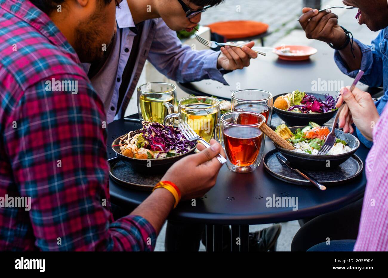 Multiracial group of friends having lunch together Stock Photo - Alamy
