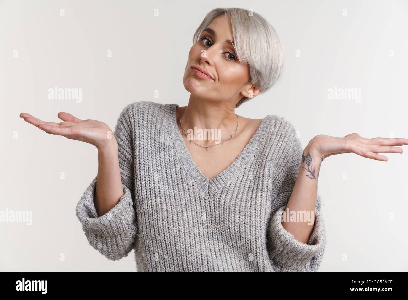 Confused beautiful silver girl showing and holding copyspace isolated ...