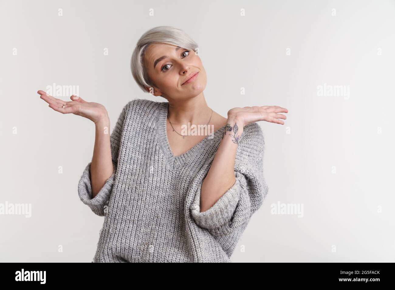 Confused beautiful silver girl showing and holding copyspace isolated ...