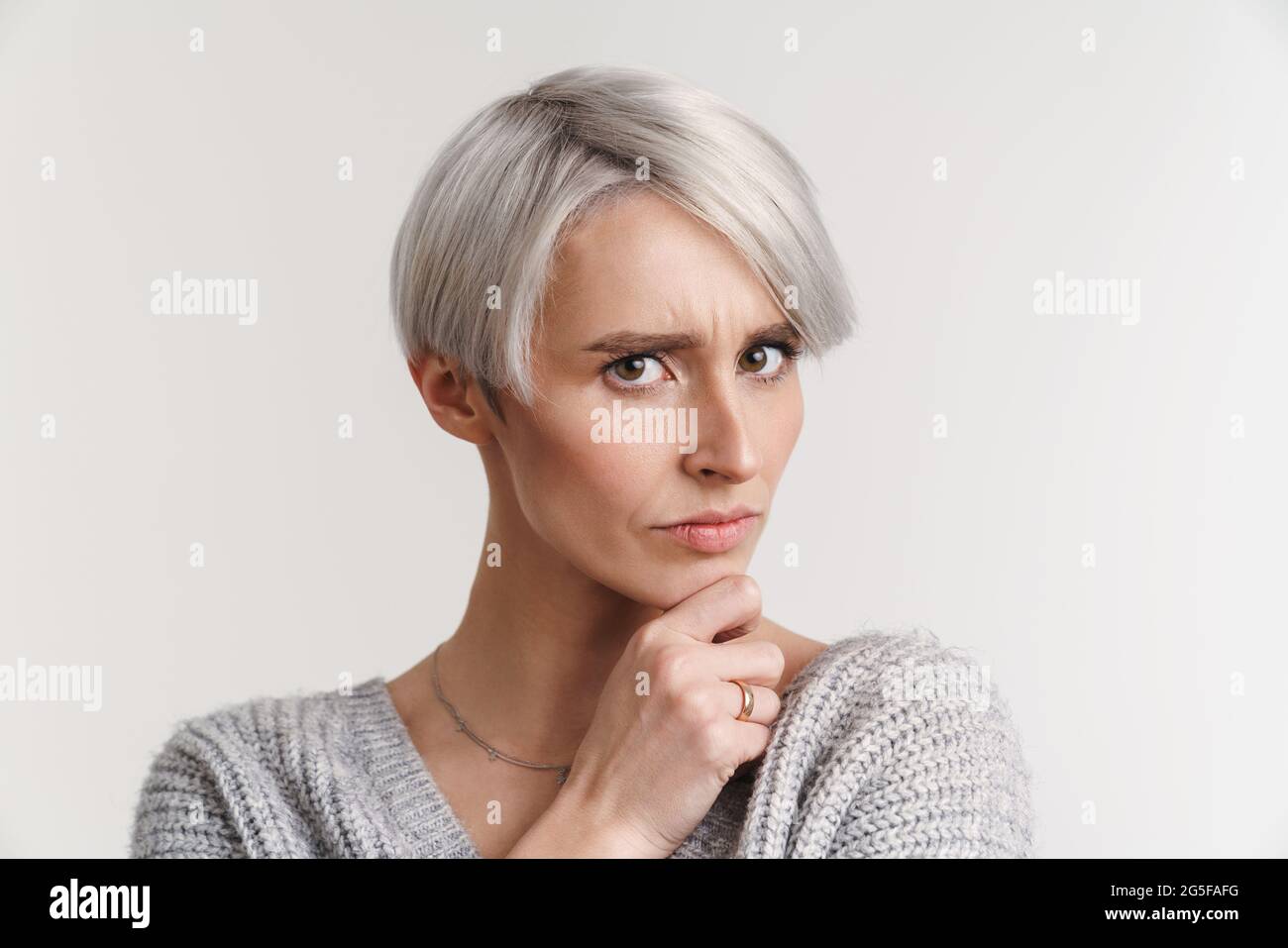Puzzled beautiful silver girl posing and looking at camera isolated ...