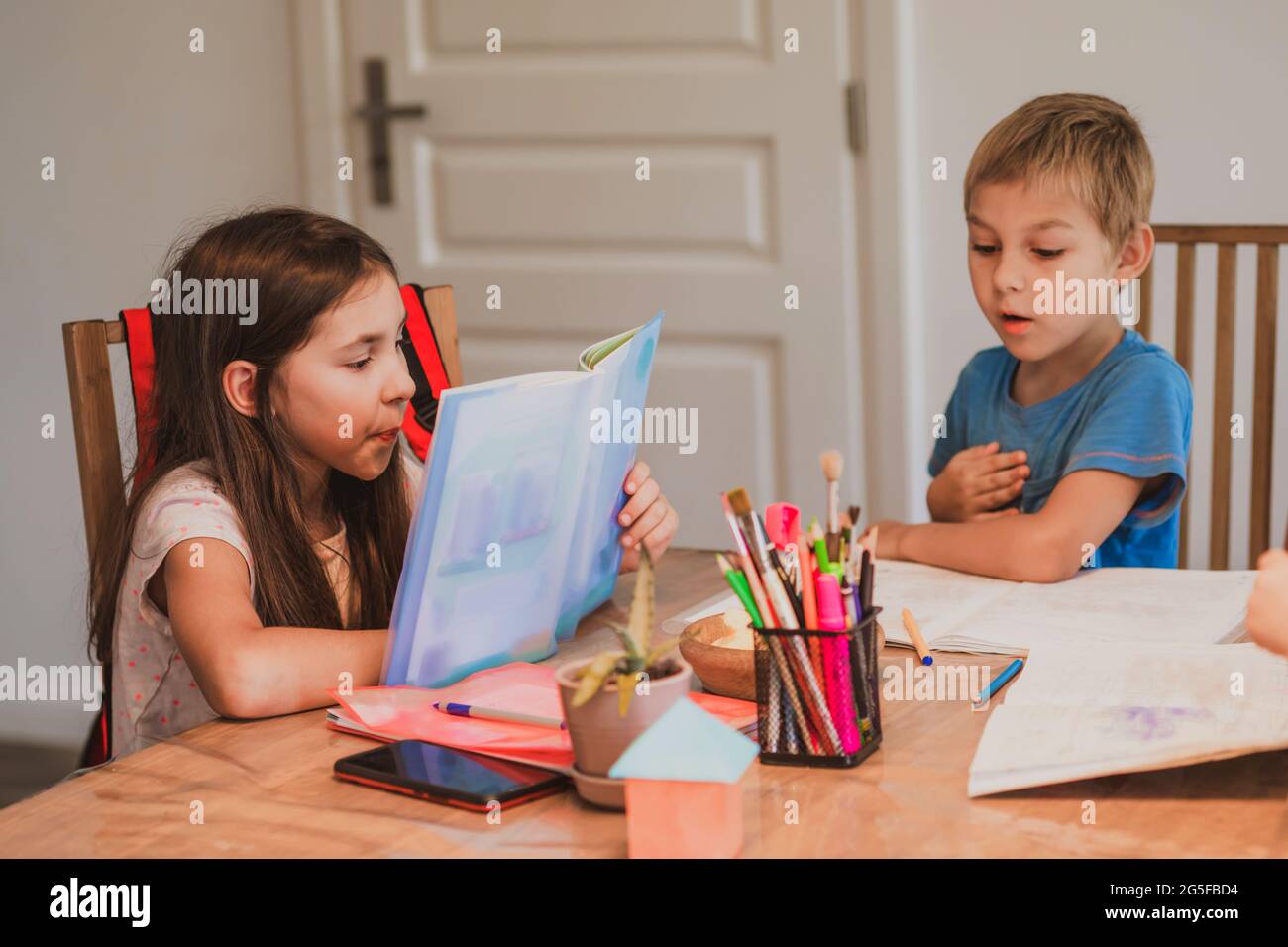 The schoolchildren are doing their homework together at home Stock ...