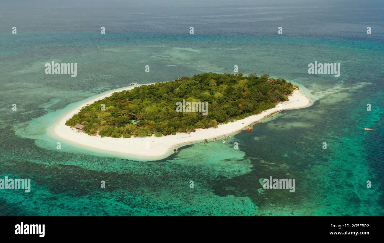 Tropical island and sandy beach surrounded by atoll and coral reef with ...