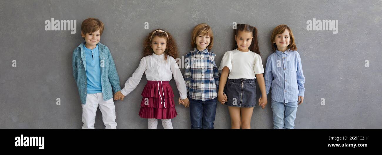 Group portrait of happy little kids in casual wear standing together ...