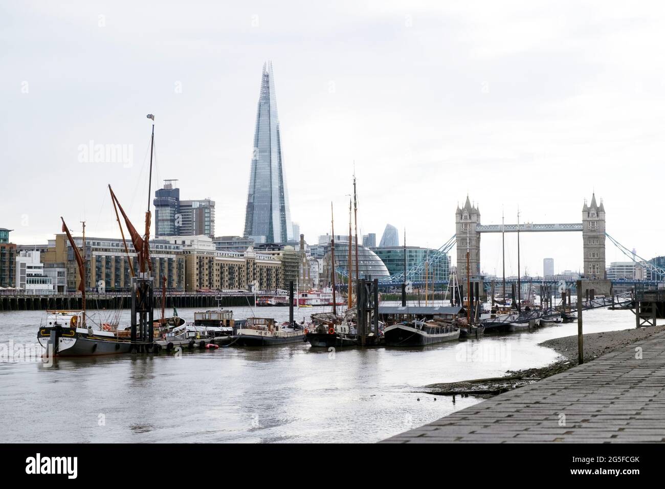 View of boats in dock near Tower Bridge and the Shard skyscraper across ...