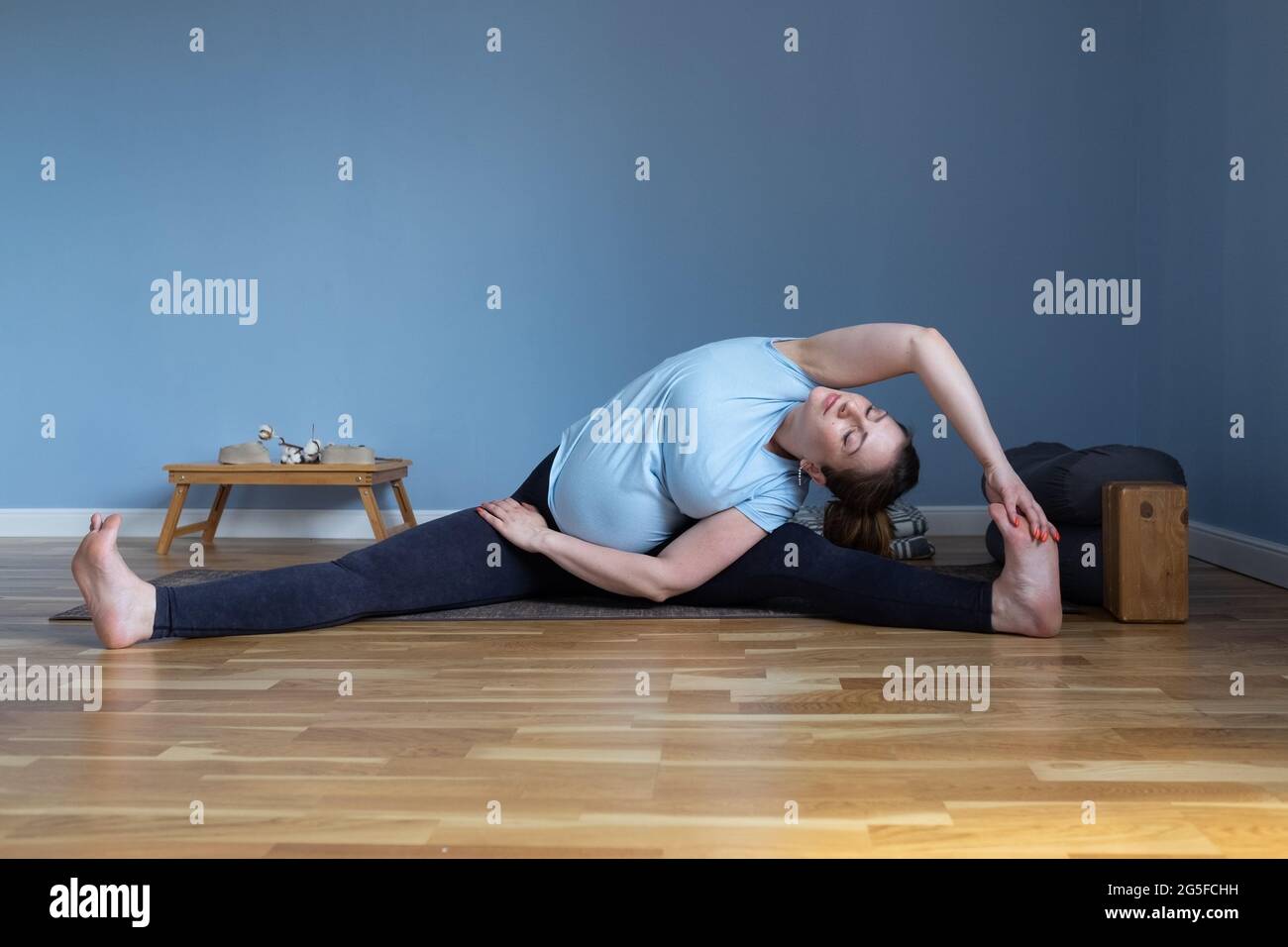woman doing yoga Wide-Angle Seated Forward Bend pose, Upavishtha ...