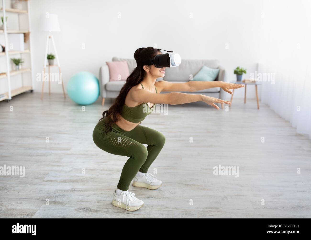 Home workout with virtual reality. Young Indian woman in VR headset ...