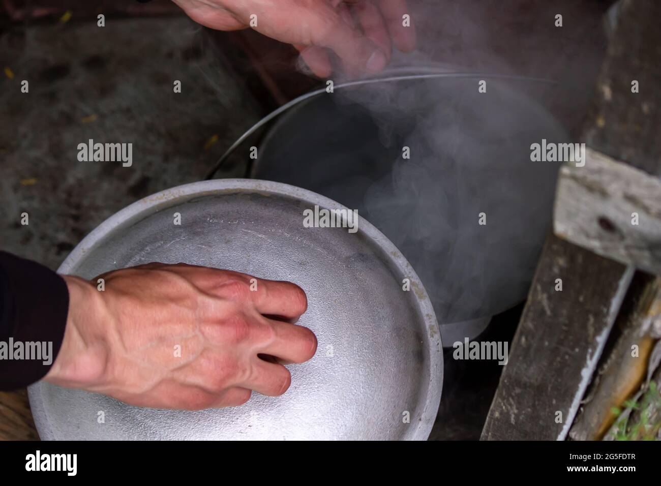 Cooking in a cast iron cauldron on a tripod over an open fire ...
