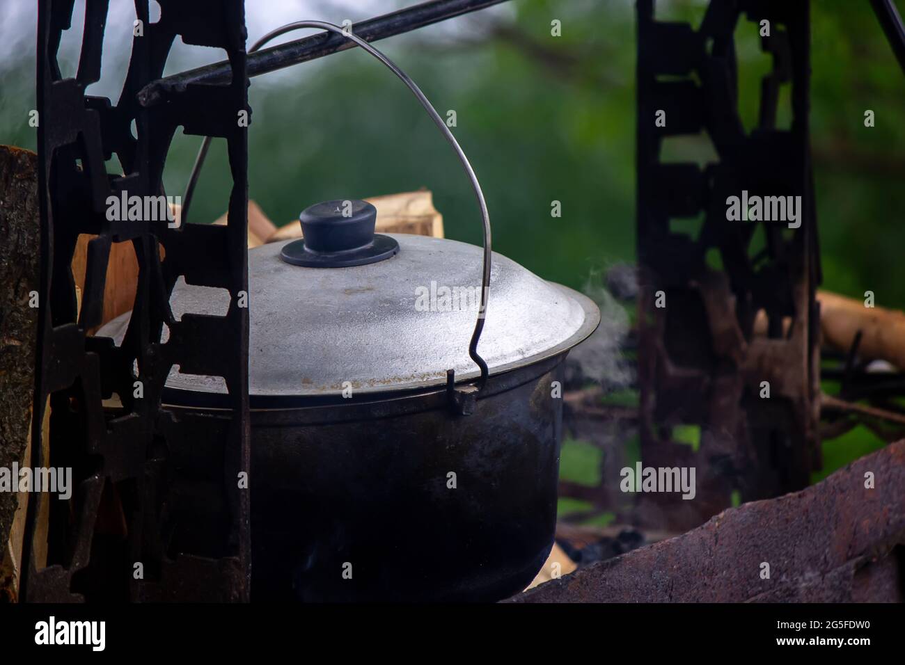 Cooking in a cast iron cauldron on a tripod over an open fire ...