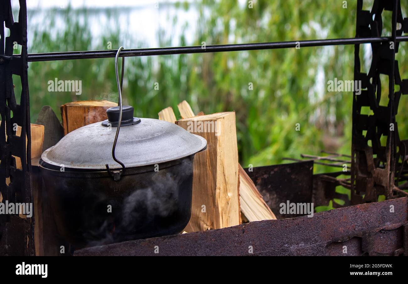 Cooking in a cast iron cauldron on a tripod over an open fire ...