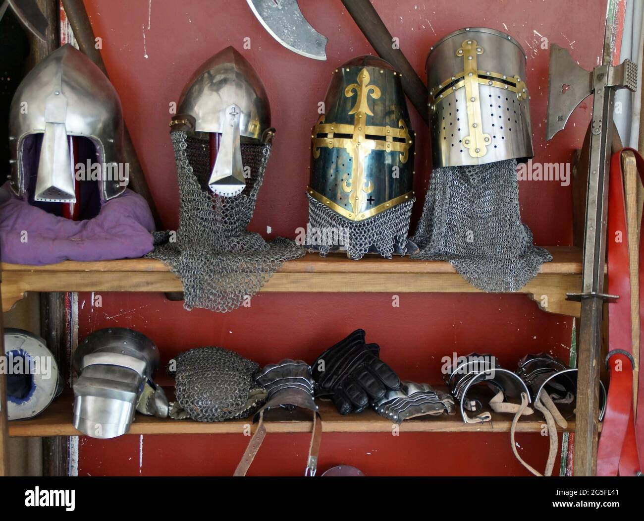 An old medieval helmets and armour displayed on a wooden rack Stock ...