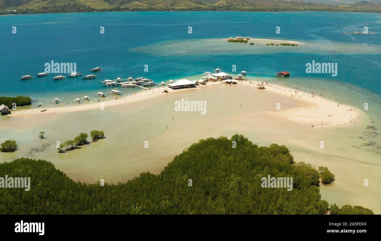 Luli island and sandy beach with tourists, sand bar surrounded by coral ...