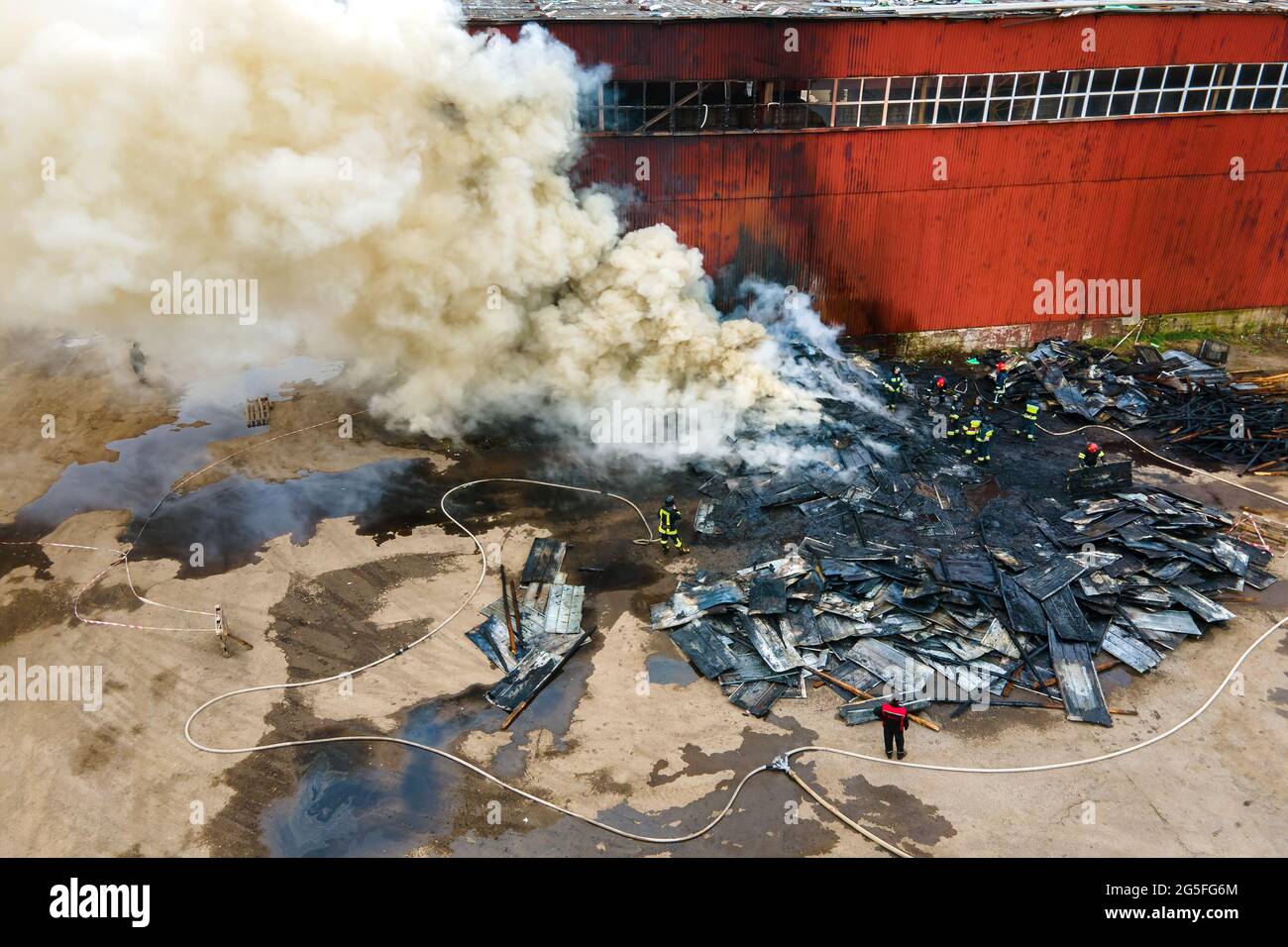Aerial view of firemen fighting with fire near old factory biulding in ...