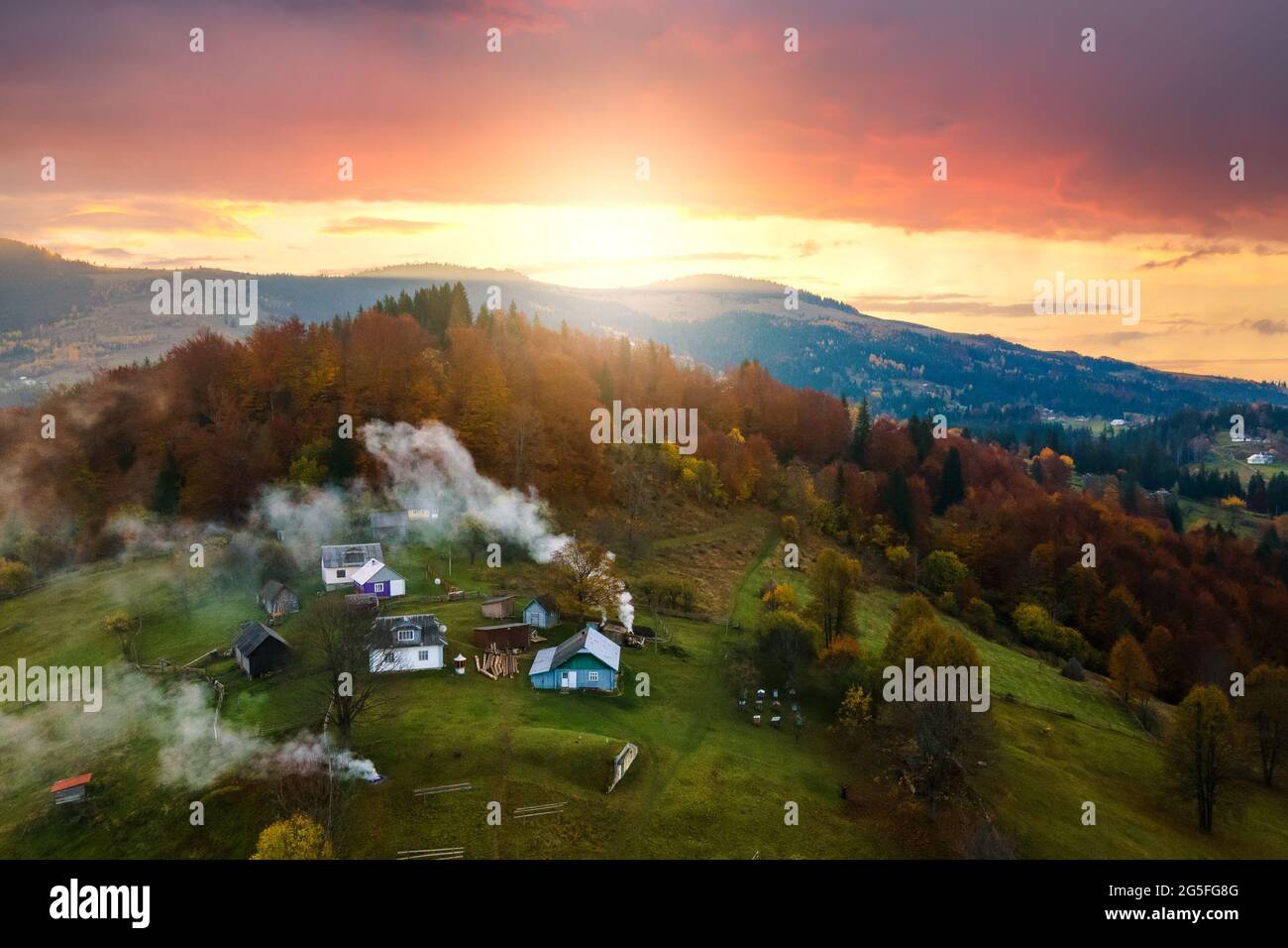 Aerial view of distant village with small shepherd houses on wide hill ...