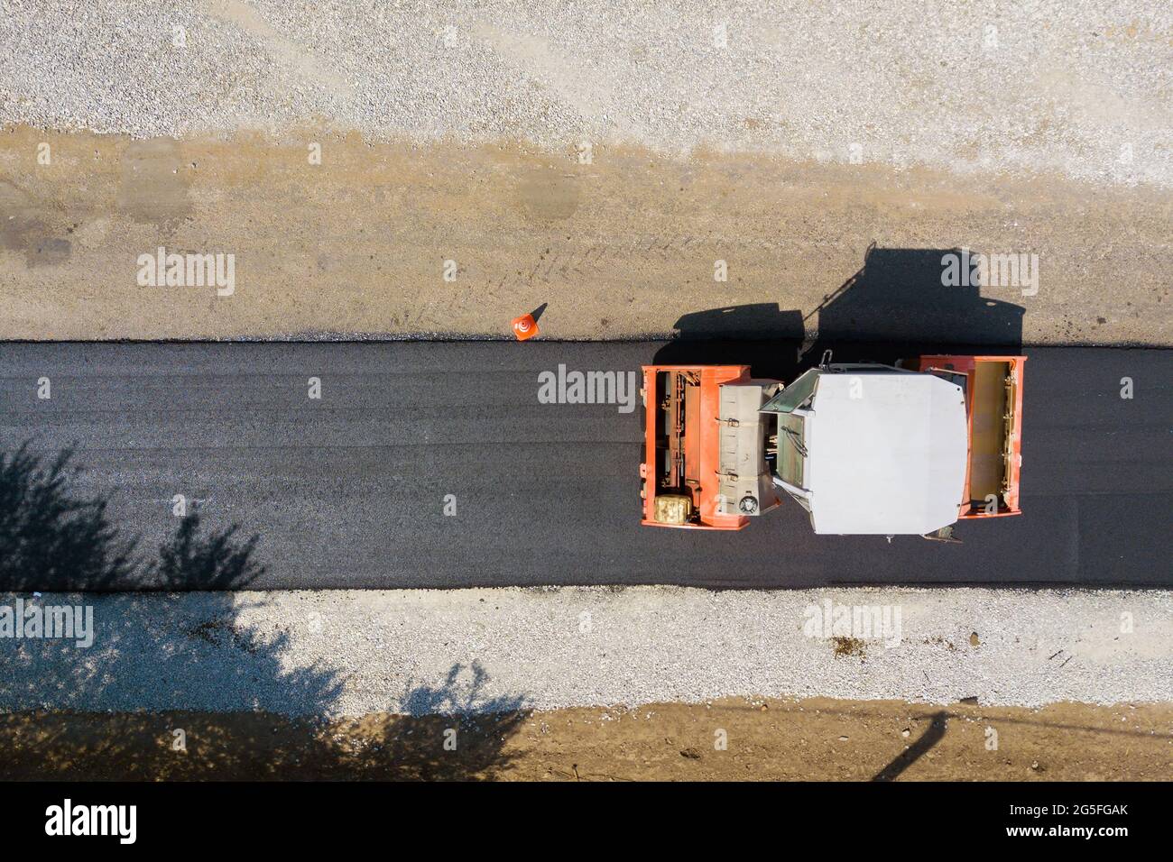 Aerial view of new road construction with steam roller machine at work ...