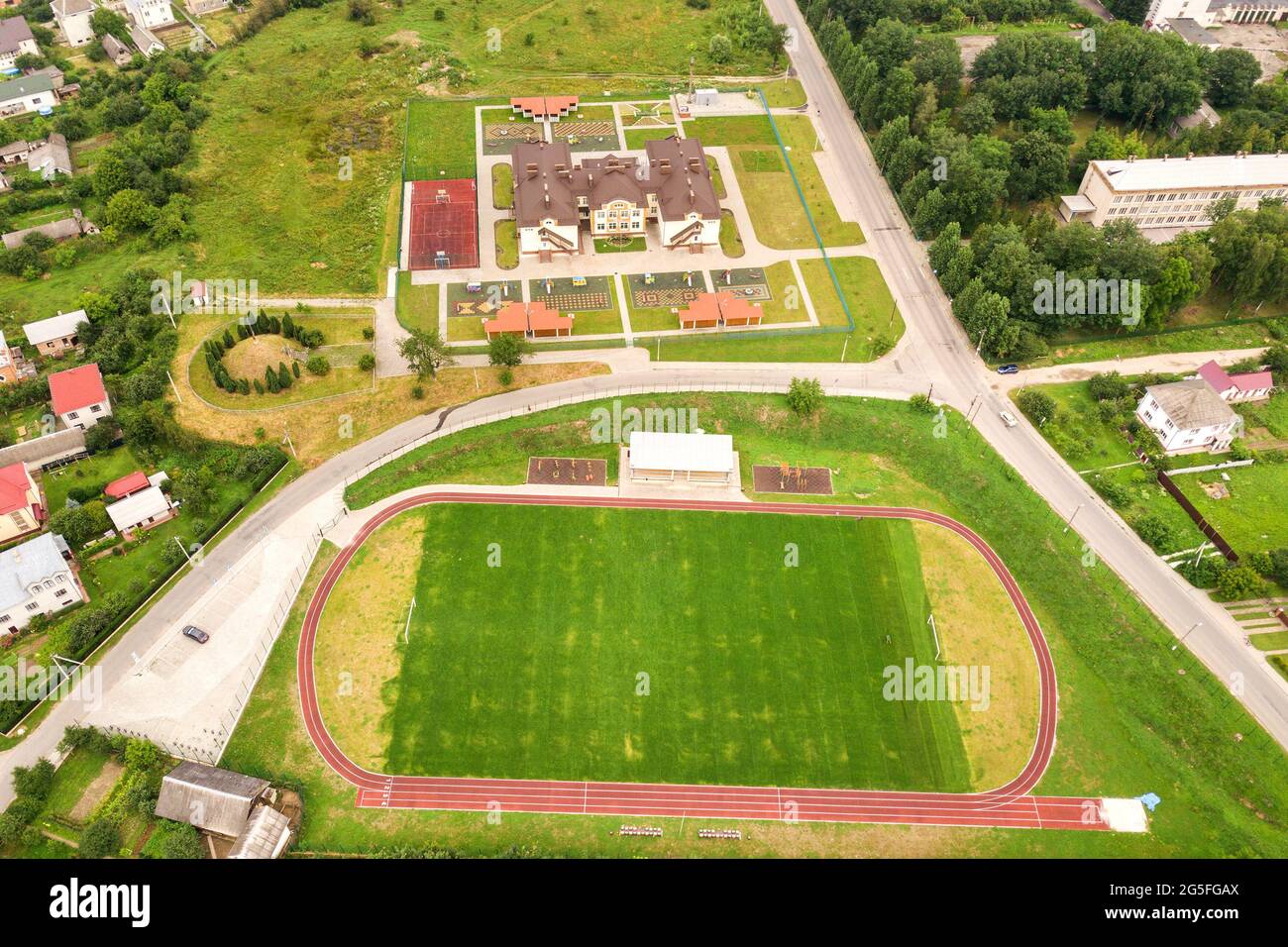 Aerial view of sports stadium with red running tracks and green grass ...