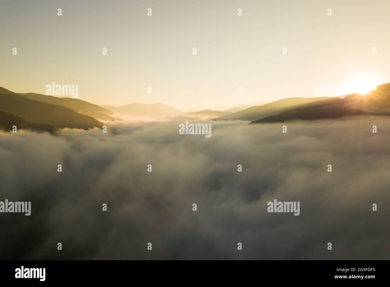 Aerial view of vibrant sunset over white dense foggy clouds with ...