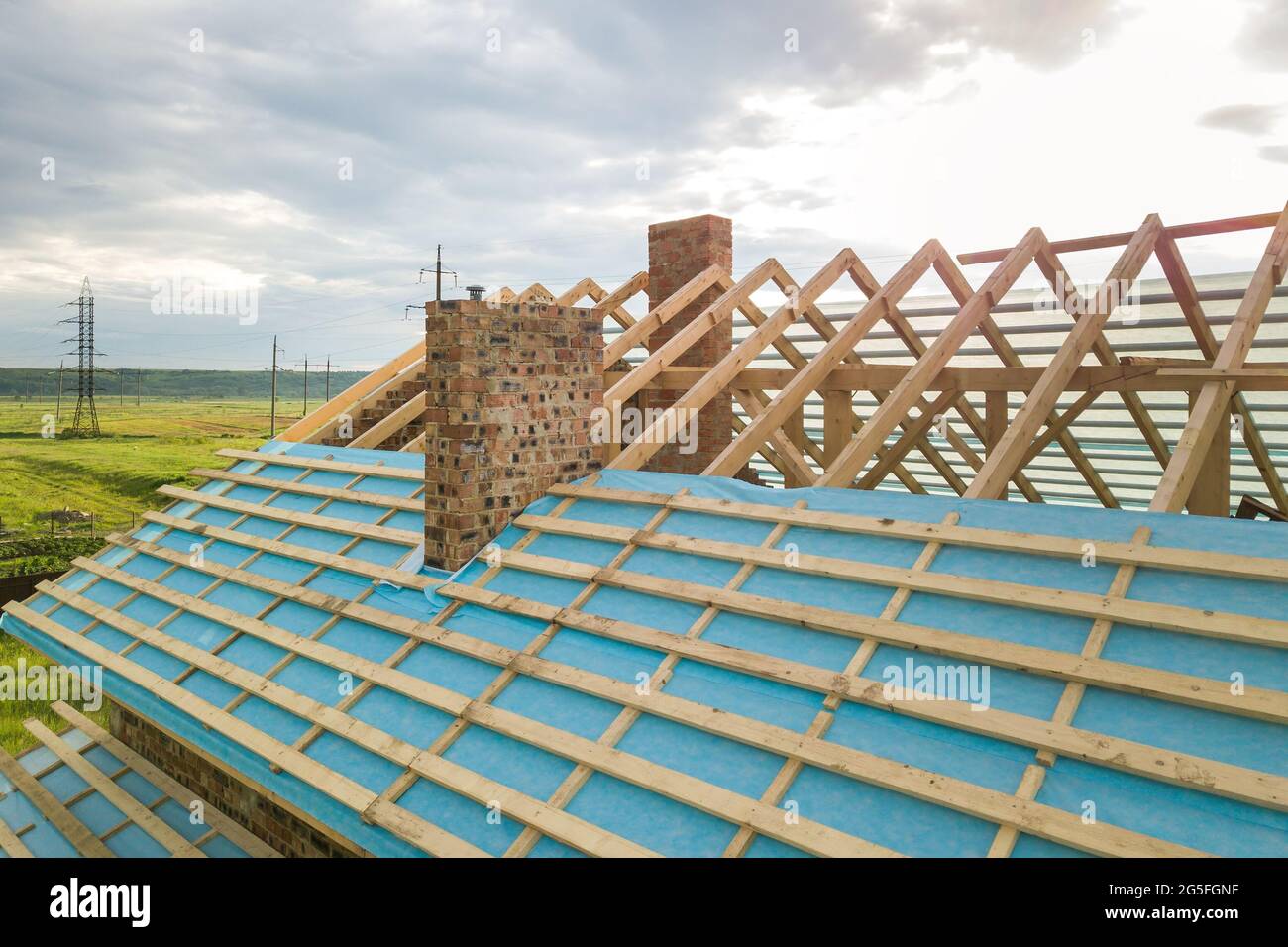 Aerial view of a brick house with wooden roof frame under construction ...