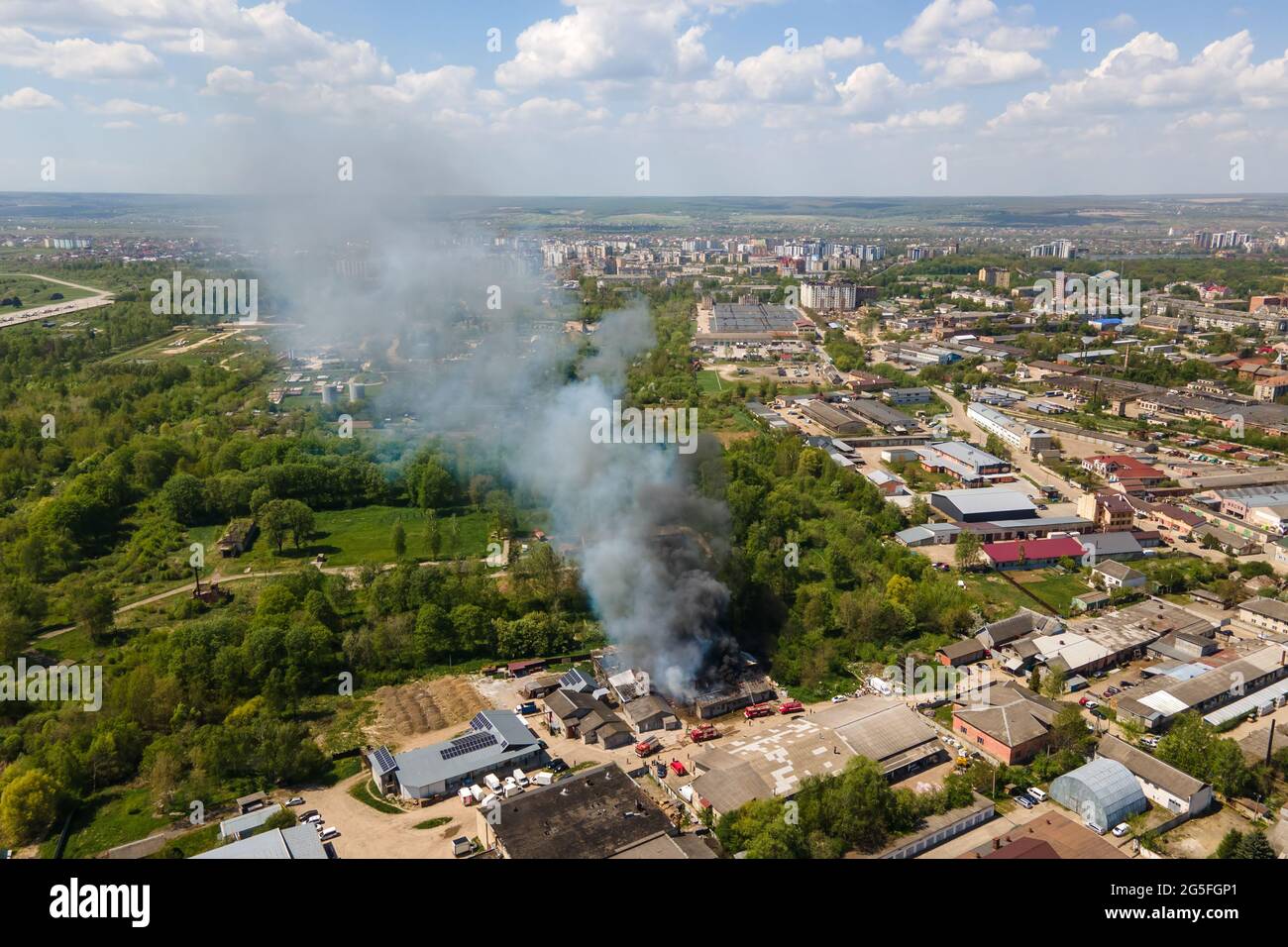Aerial view of firefighters extinguishing ruined building on fire with ...