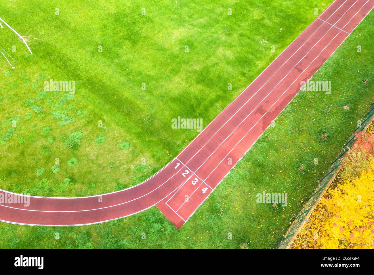 Aerial view of sports stadium with red running tracks with numbers on ...