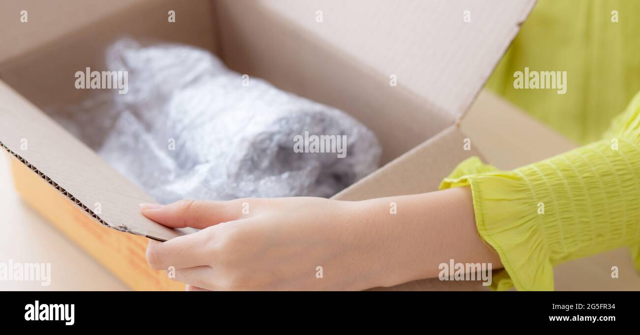 Closeup hand of woman opening parcel box with check product at home ...