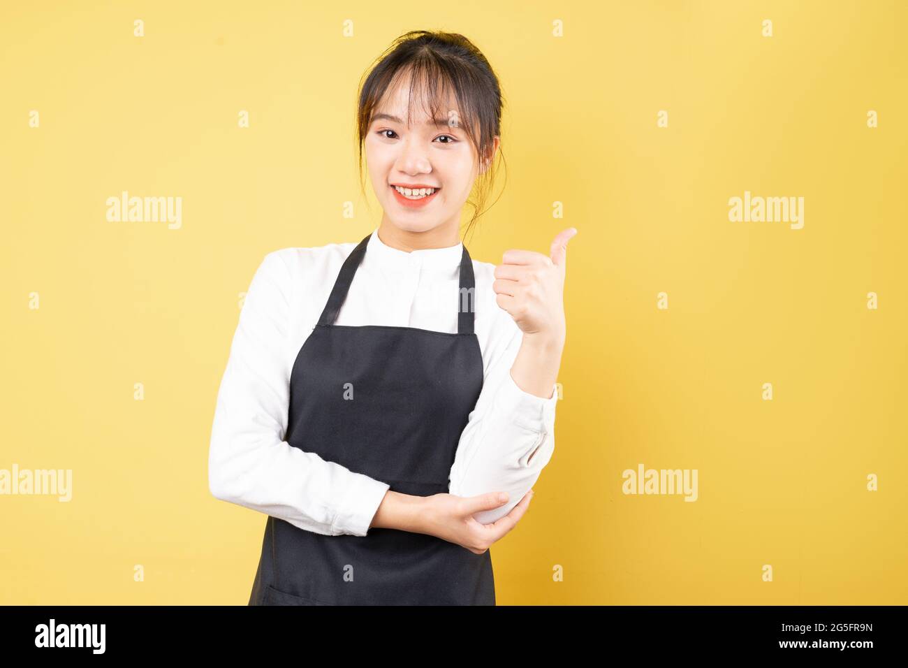 Portrait of cheerful waitress on yellow background Stock Photo - Alamy