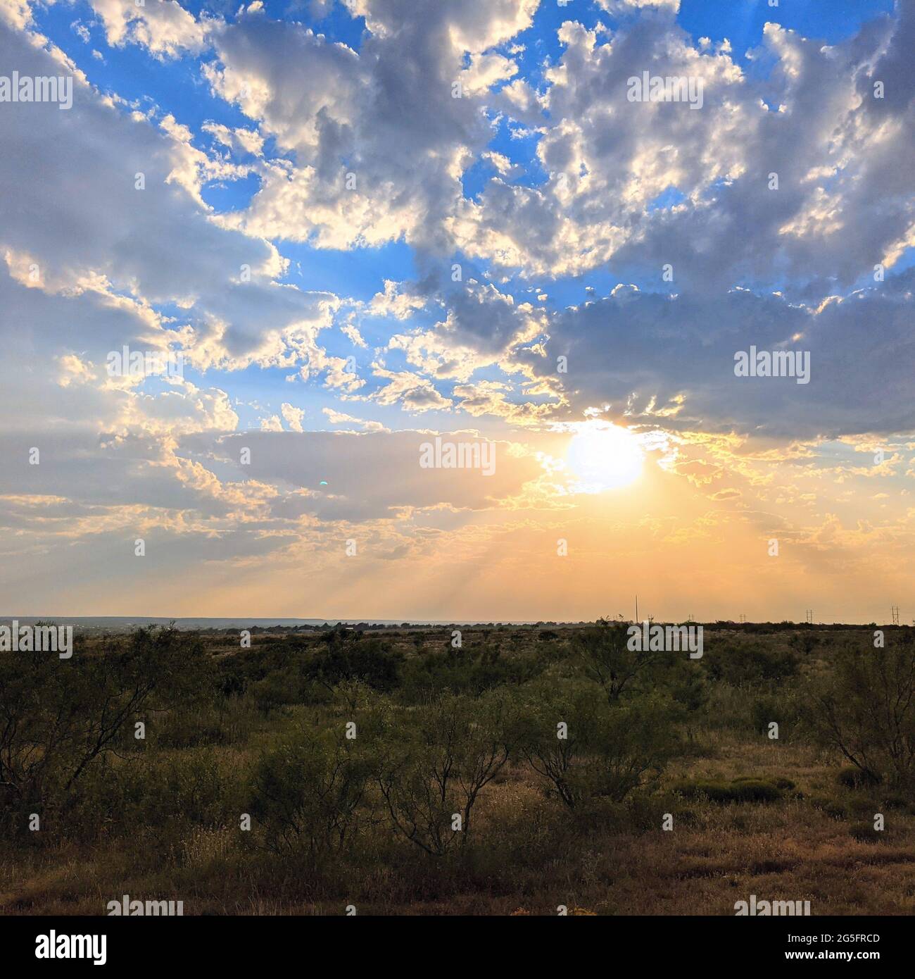 Sun shining in the afternoon over a vast plain while clouds are seen in ...