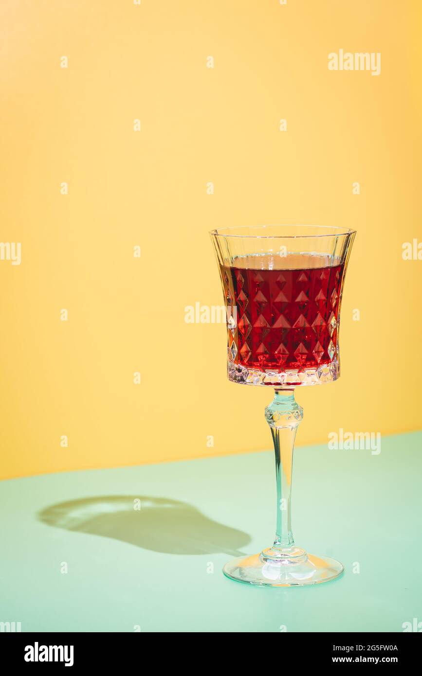 Wine Glass of red wine over yellow background Stock Photo - Alamy