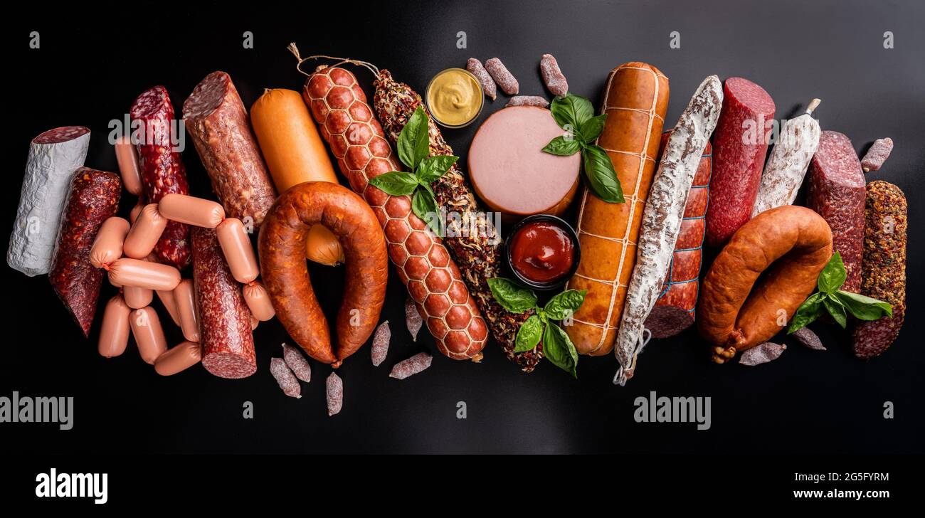 Set of different types of sausages, salami and smoked meat with basil ...